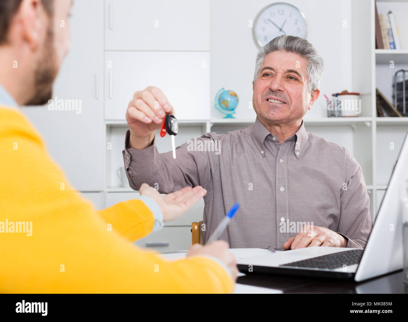 Mature man and manager signed car purchase contract at office and hand ...