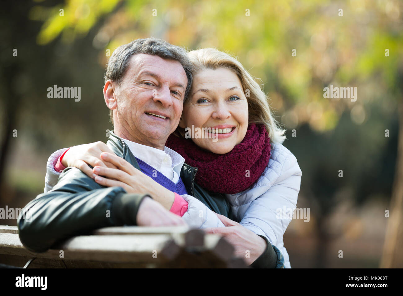 Happy pensioners cuddling in park and enjoying time together Stock ...