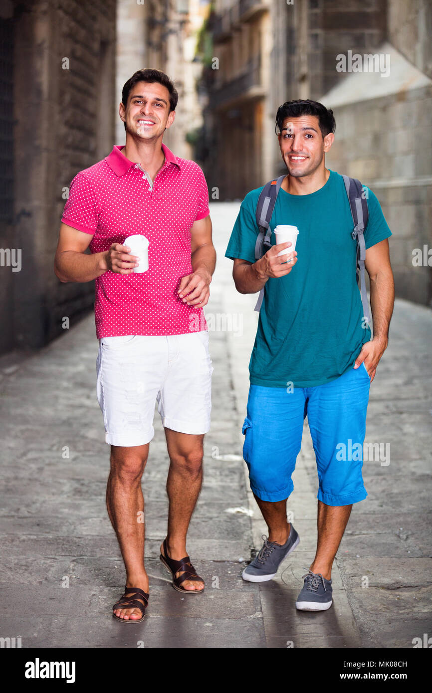 Happy cheerful positive smiling men friends are drinking coffee in time ...