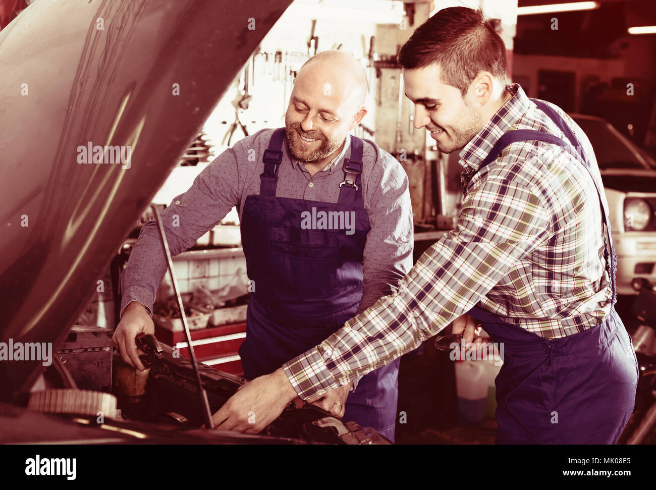Portrait of two happy professional car mechanics at workshop Stock ...