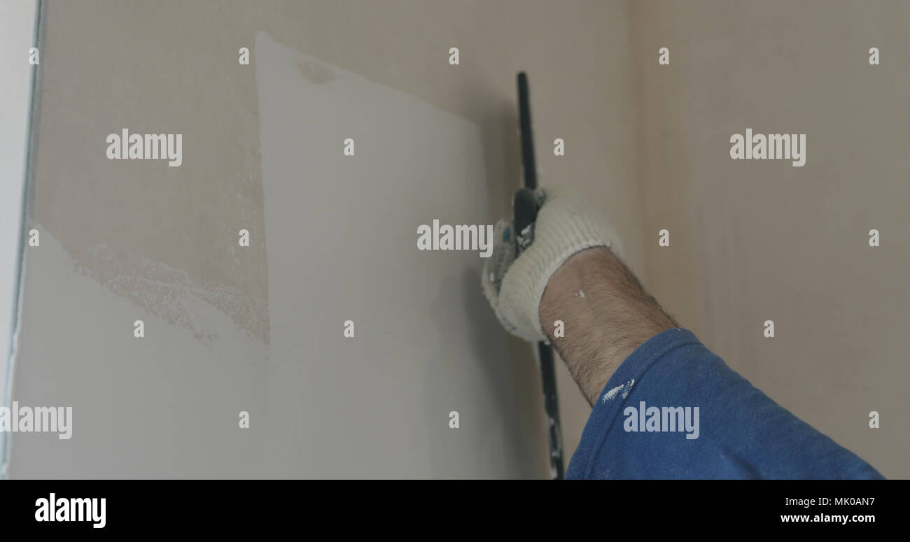 worker applying putty on the wall Stock Photo - Alamy
