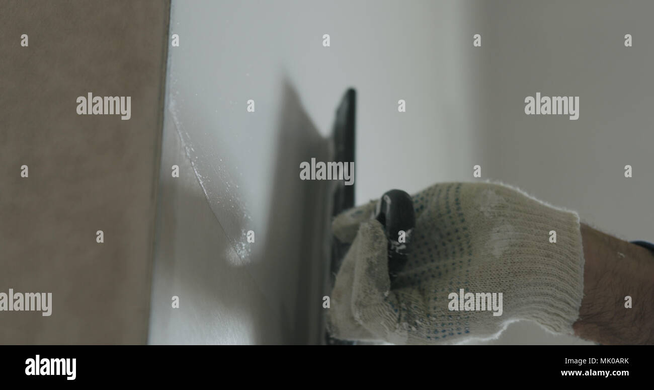 worker applying putty on the wall with copy space Stock Photo - Alamy