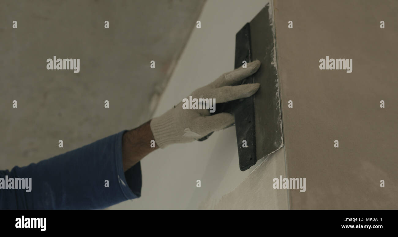 worker applying putty on the wall near corner Stock Photo - Alamy