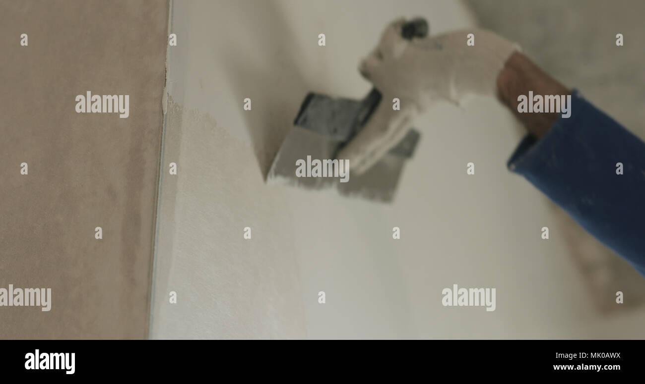worker applying putty on the wall Stock Photo - Alamy