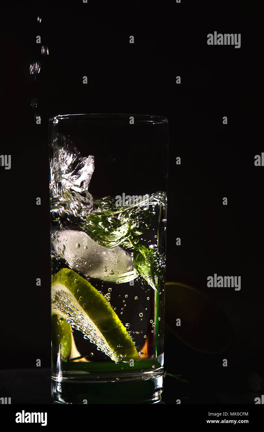 Cold fresh water with bubbles, lime, ice and mint in glass. Healthy ...