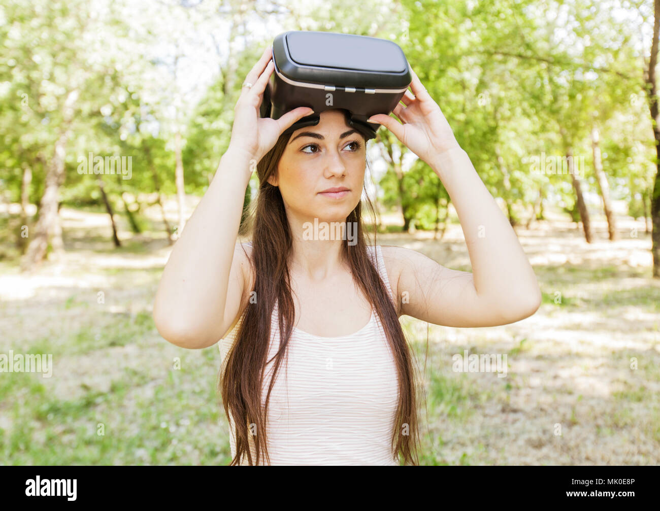 Attractive woman wearing virtual reality goggles outdoor, nature and ...