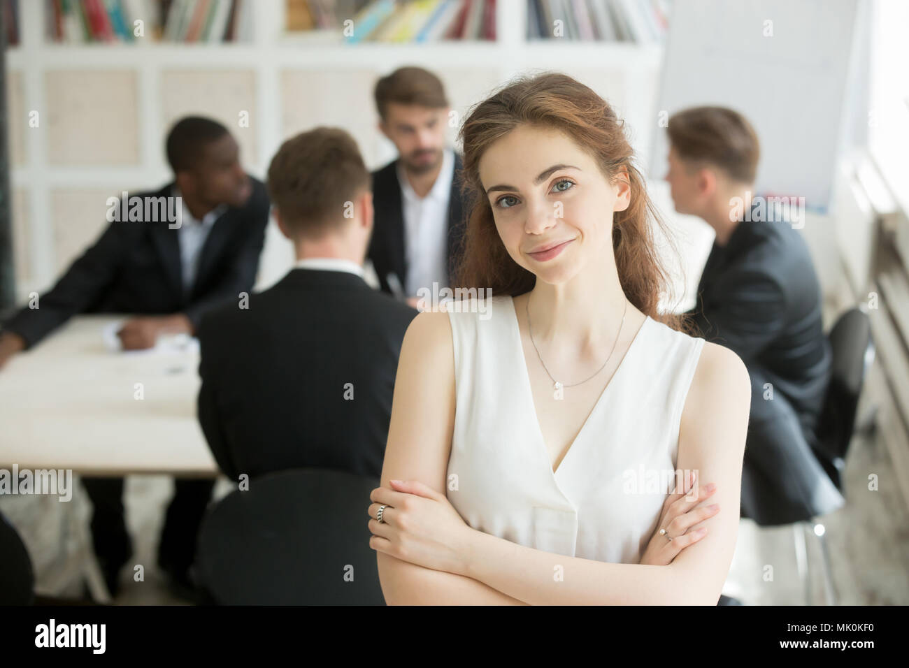 Attractive female leader posing in front of colleagues Stock Photo - Alamy