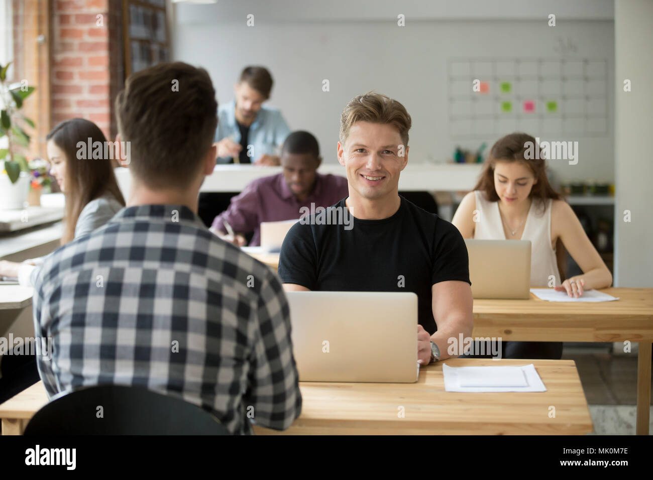 Confident male freelancer smiling at camera Stock Photo - Alamy