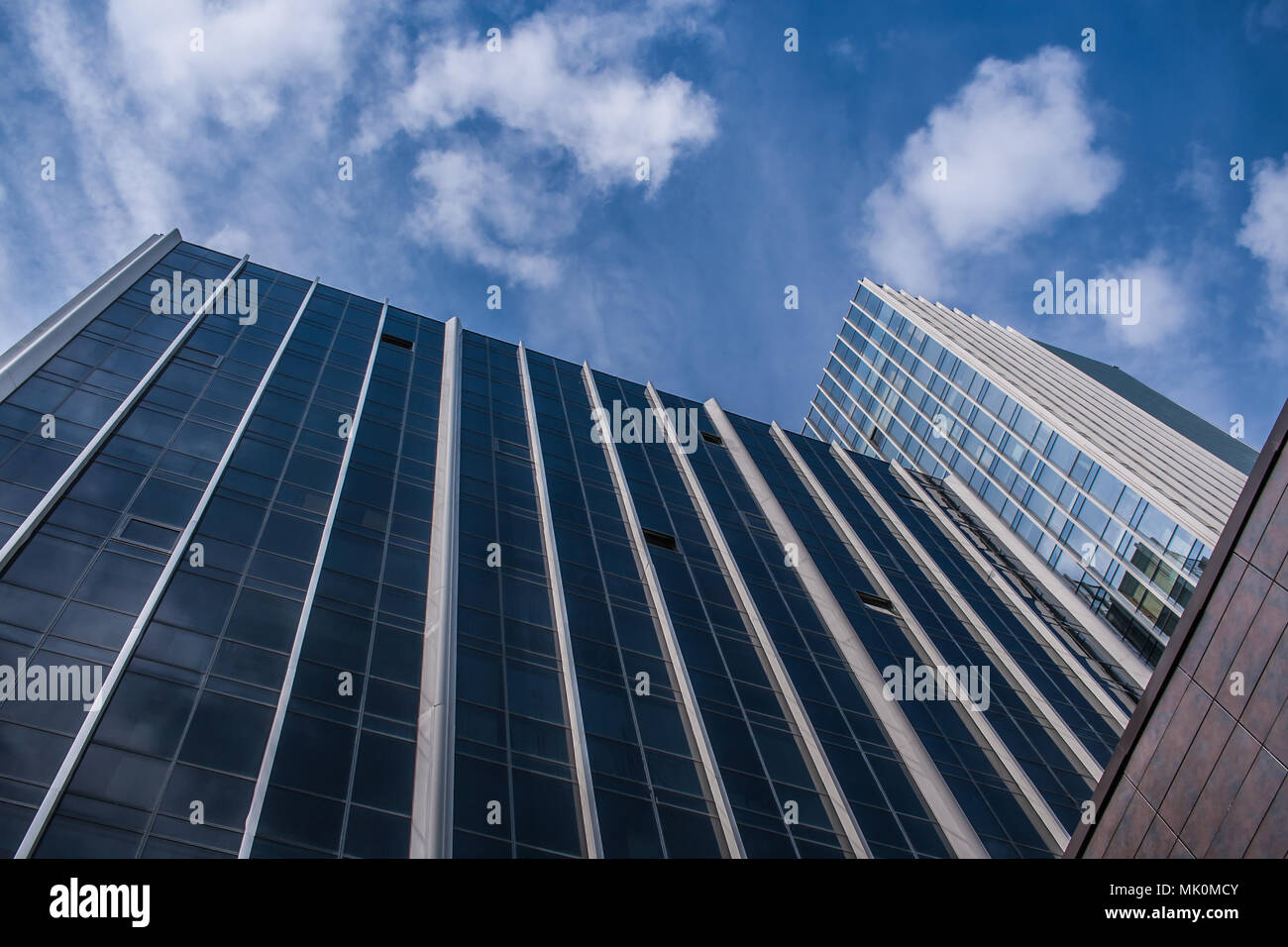 Bottom view of facades of modern glass office buildings and blue sky up ...