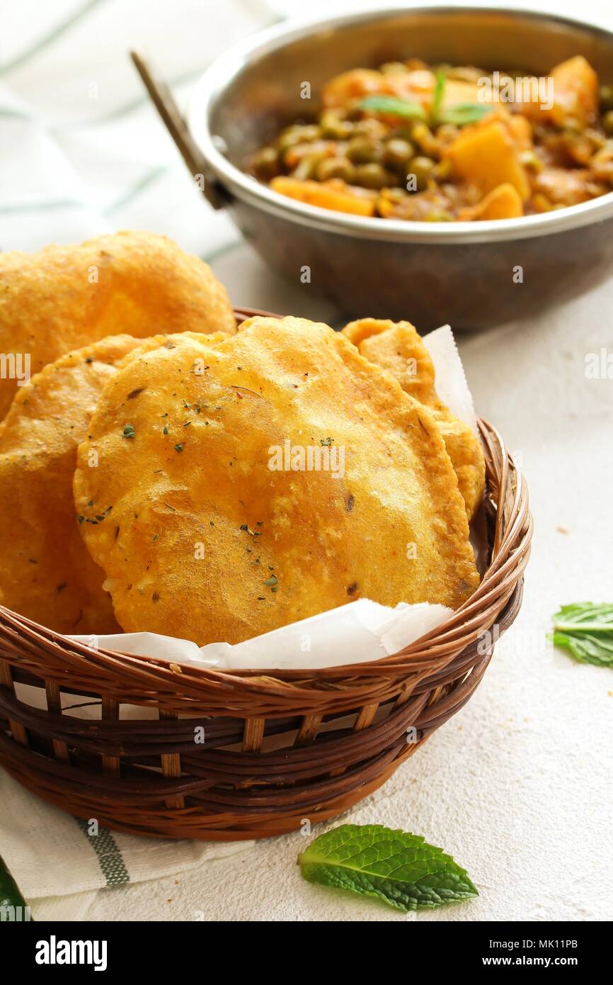 Homemade Indian Potato Poori or Puri served with Alu Matar, selective ...
