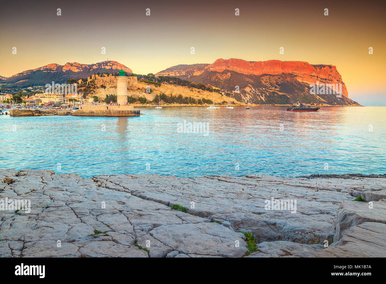 Amazing sunset with Cassis harbor, lighthouse and high colorful cliffs ...