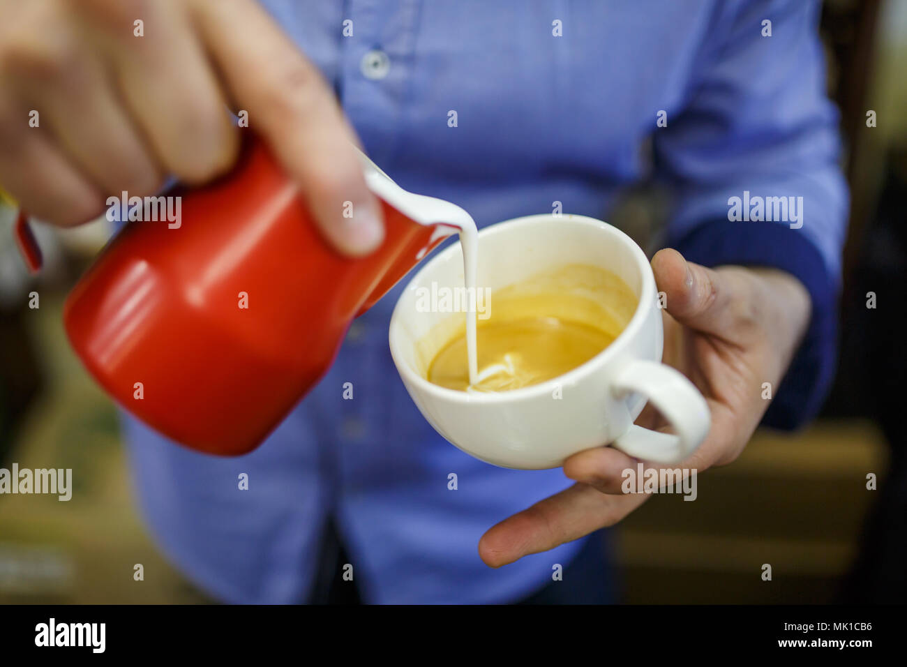 Picture of barista man pouring cream into cup of coffee Stock Photo - Alamy