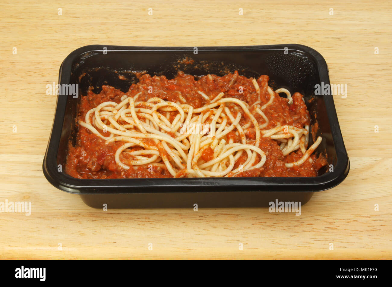 Spaghetti Bolognese in a carton on a wooden chopping board Stock Photo ...