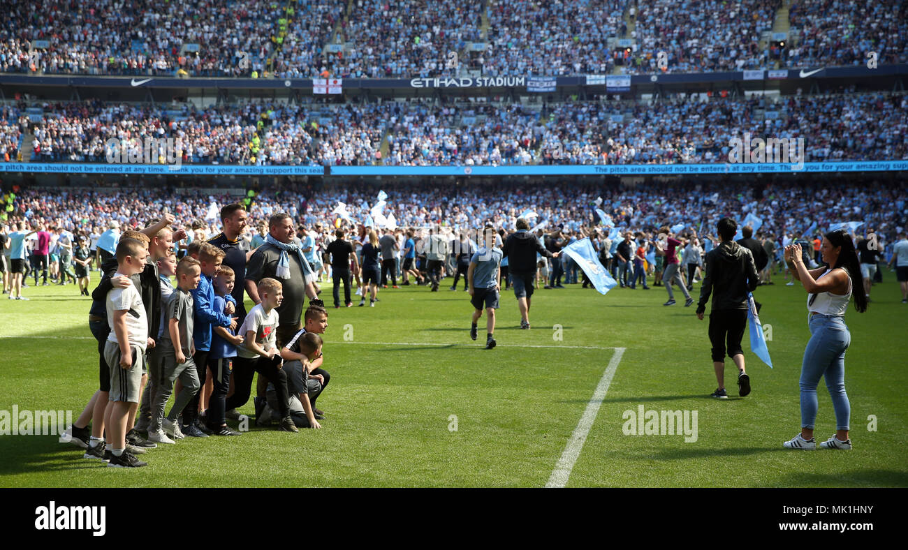Fans pose for a picture during the pitch invasion after the Premier ...