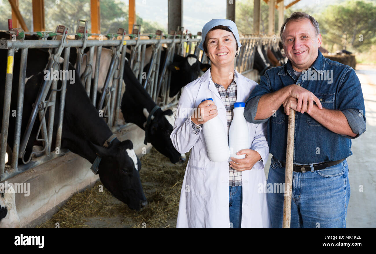 Smiling male and female workers posing on cow farm Stock Photo - Alamy