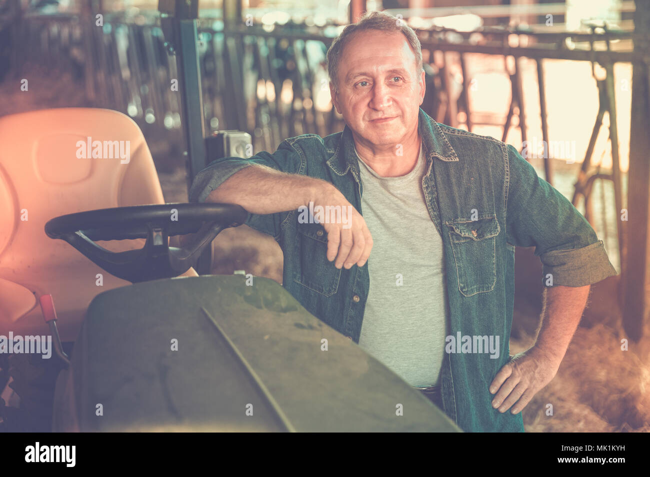 Confident male farm owner driving tractor Stock Photo - Alamy
