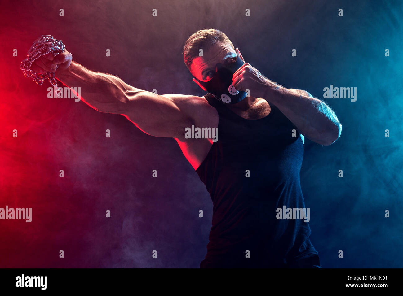 Serious muscular fighter in Training Mask doing the punch with the ...
