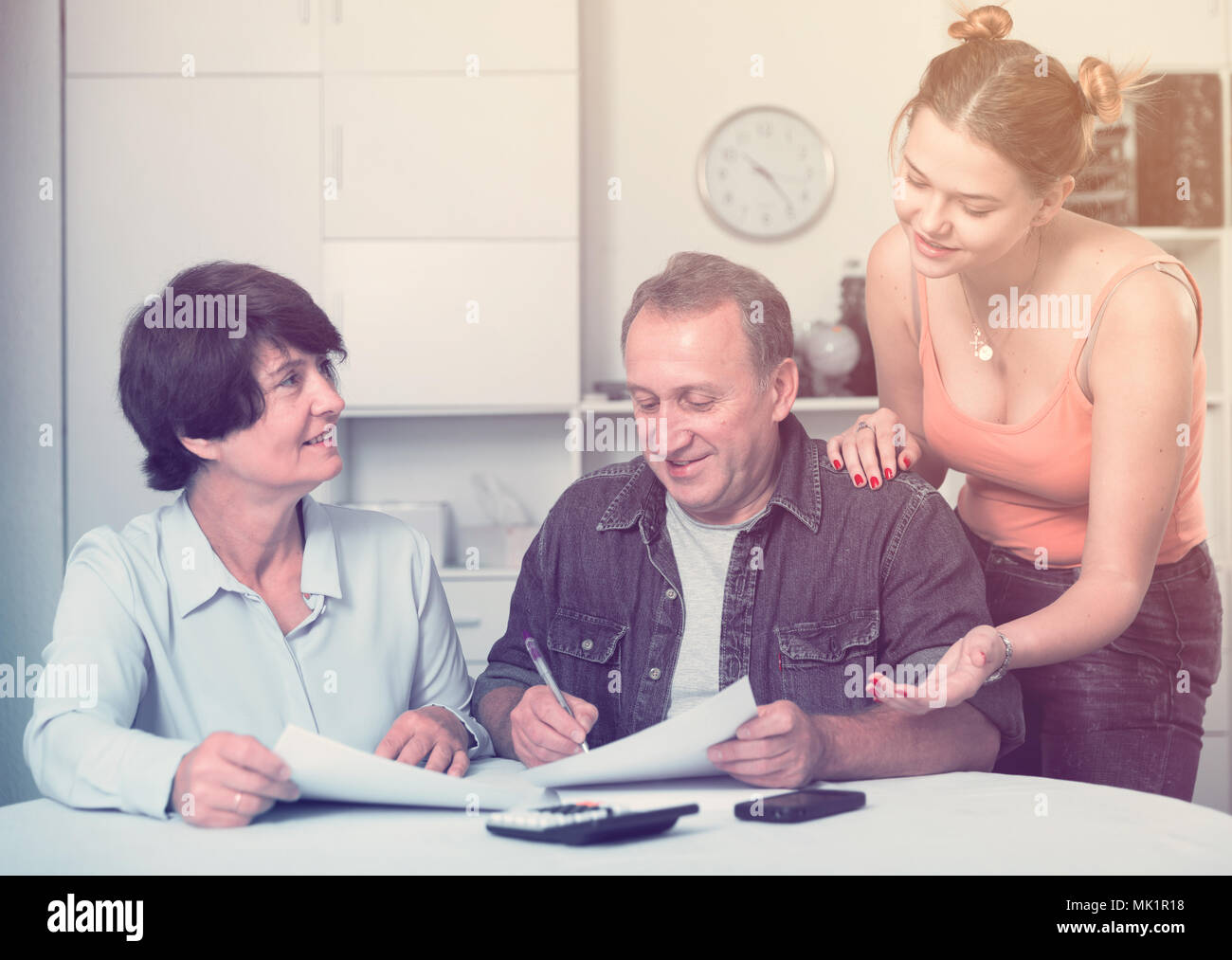 Adult couple is singing contract with their daughter indoor Stock Photo ...