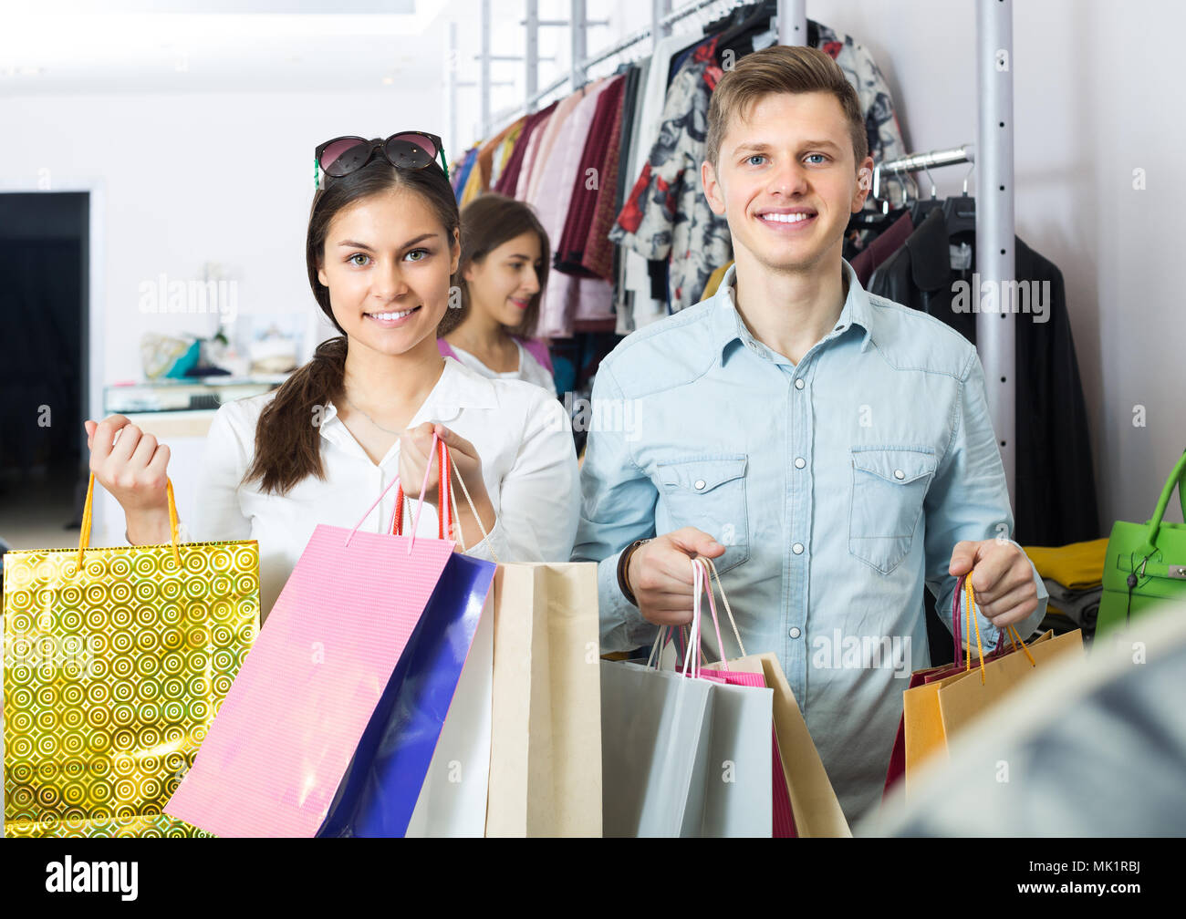Cheerful smiling couple doing big shopping at the clothing shop Stock ...
