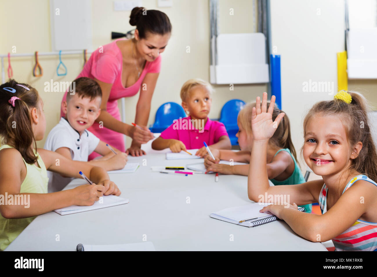 Cheerful diligent kids learning to write on lesson in elementary school ...