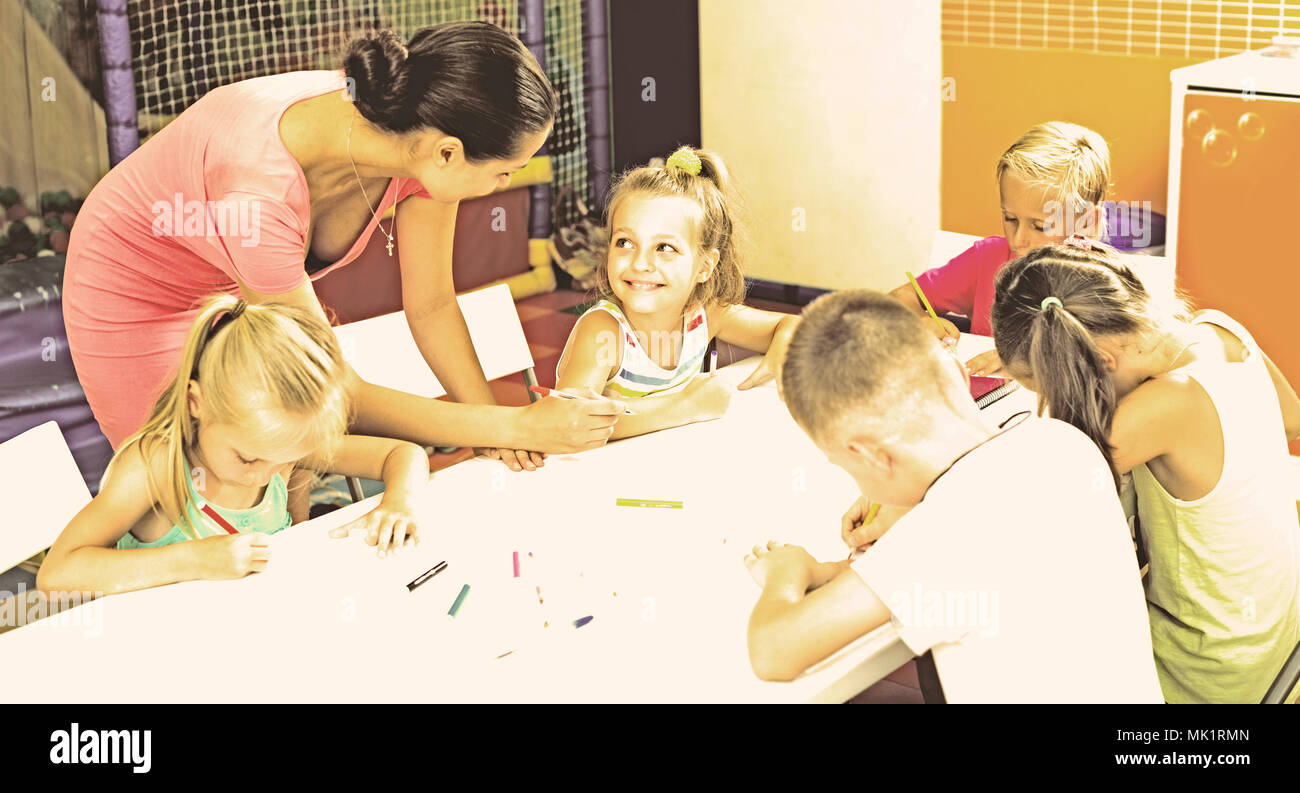 Smiling children drawing pencils on lesson in elementary school class ...