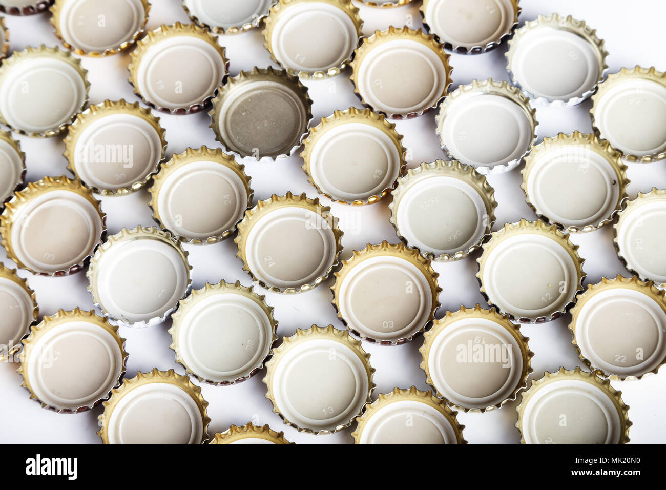 many inverted covers of beer are laid out in rows, the background. top ...