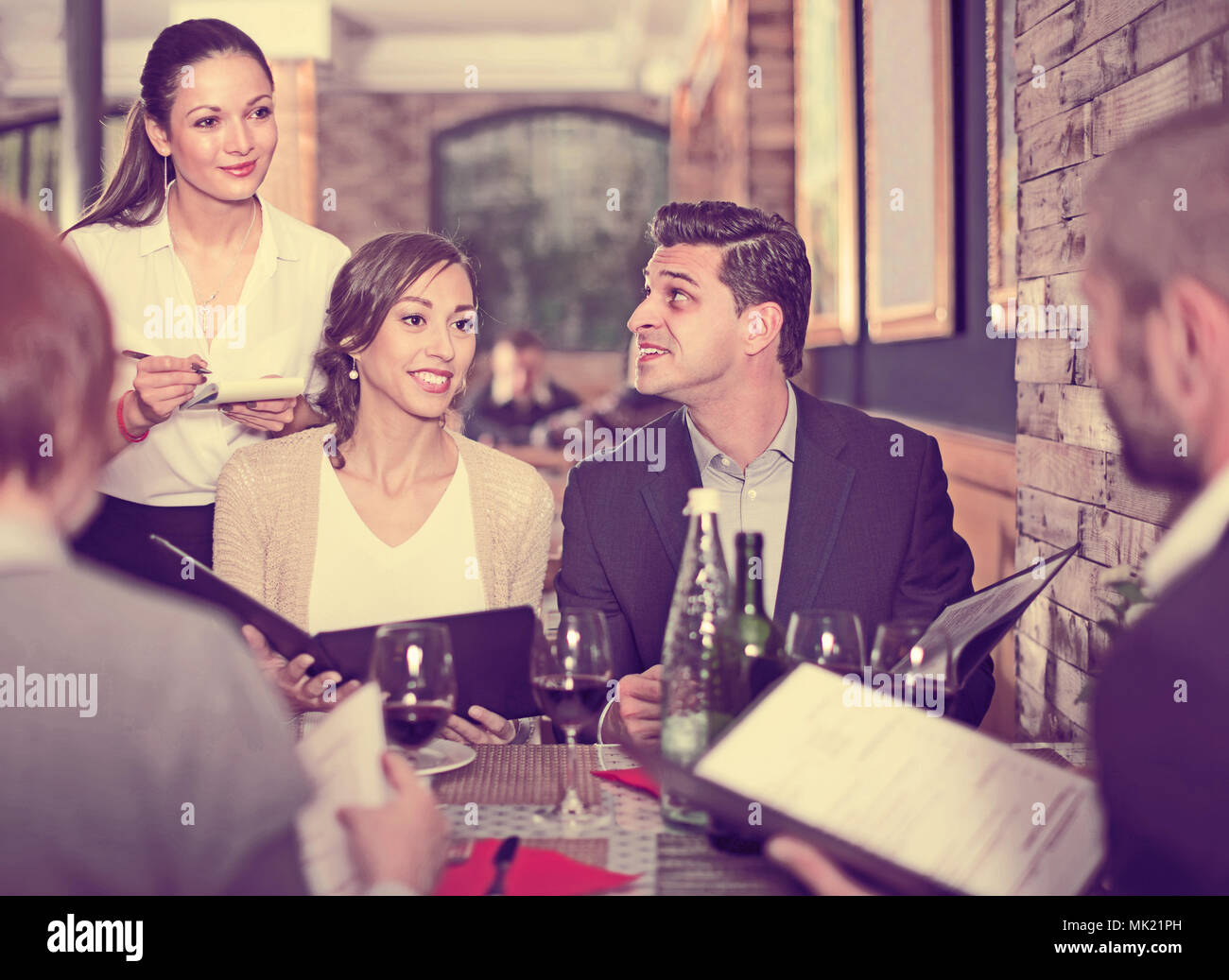 Employee waitress female taking order from positive visitors at ...