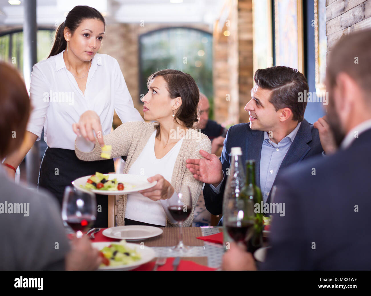 Company of people expressing dissatisfaction with the waitress about a ...