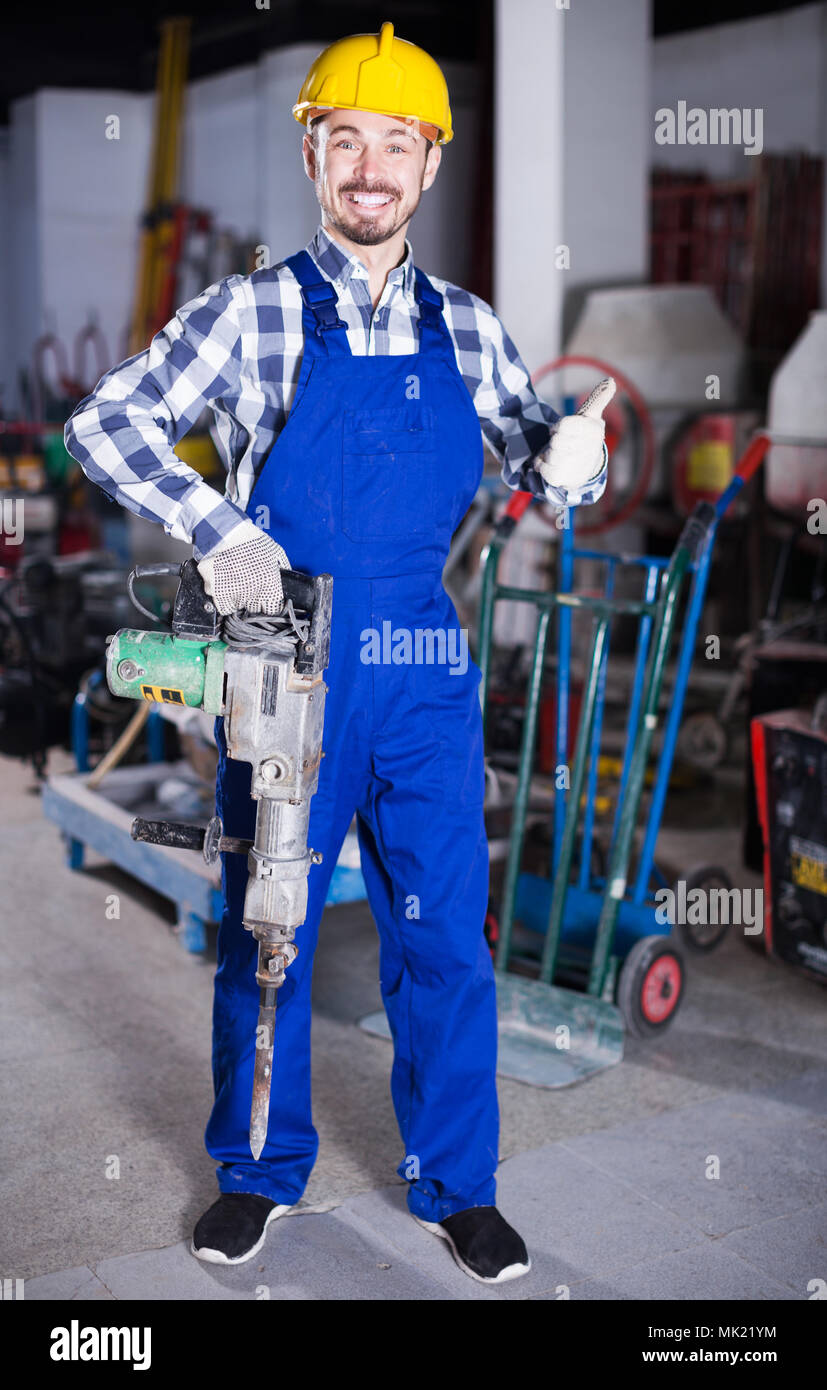Adult worker starting to work with demolition hammer at workshop Stock ...