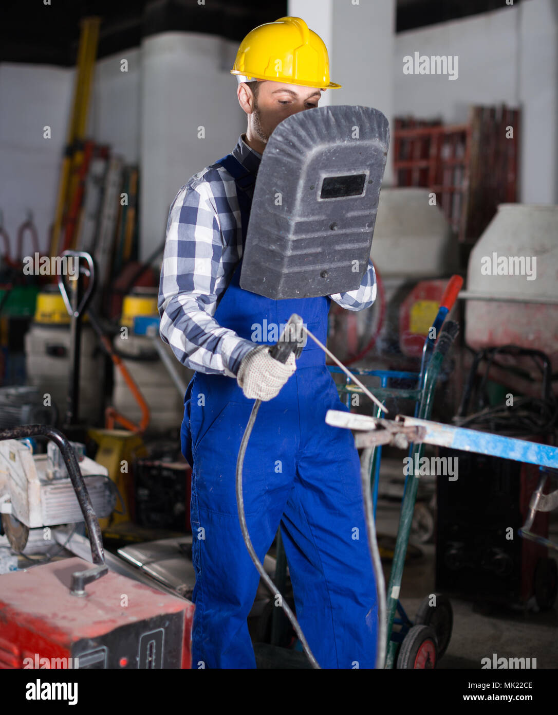 Adult guy is starting to work with welding machine at workshop Stock ...