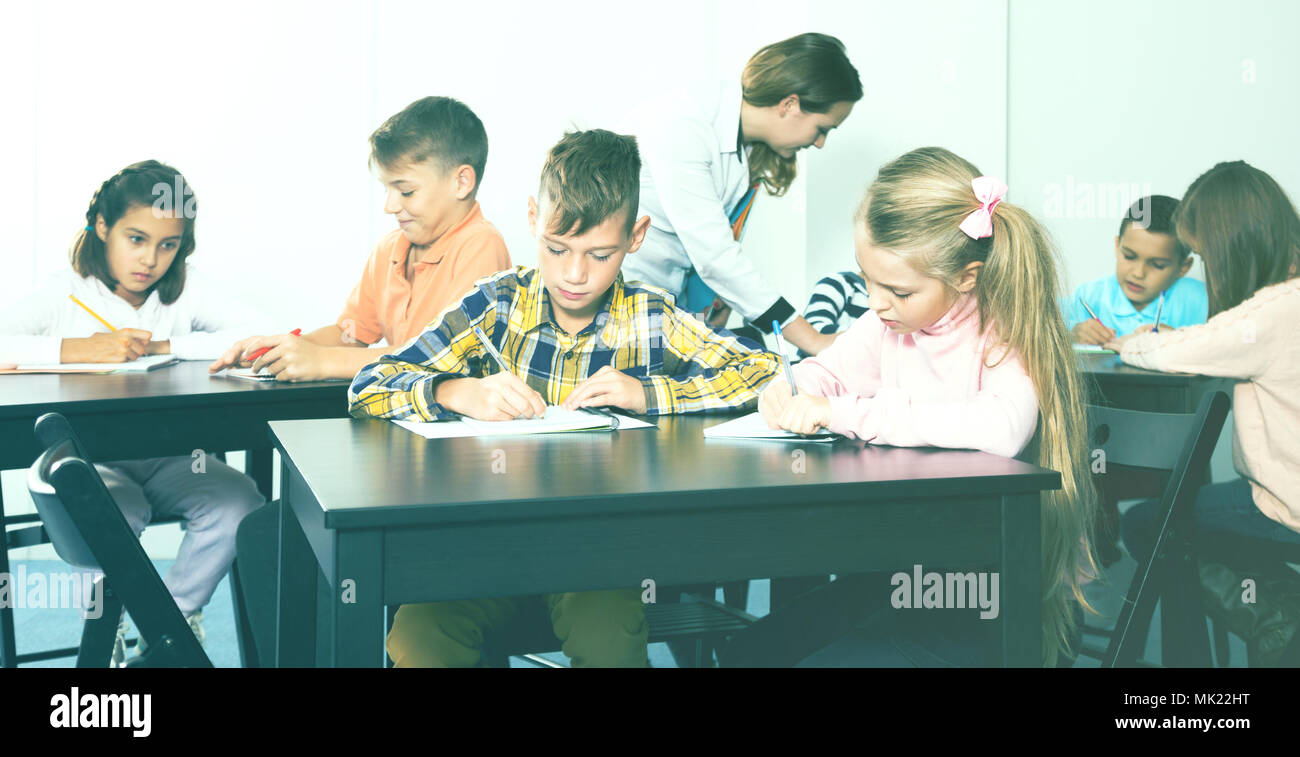 Cheerful professor and elementary age children at classroom Stock Photo ...