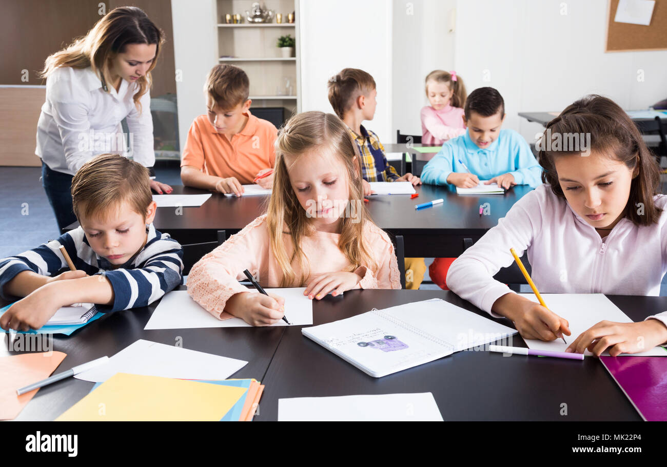 Professor and elementary age children in classroom at a school Stock ...
