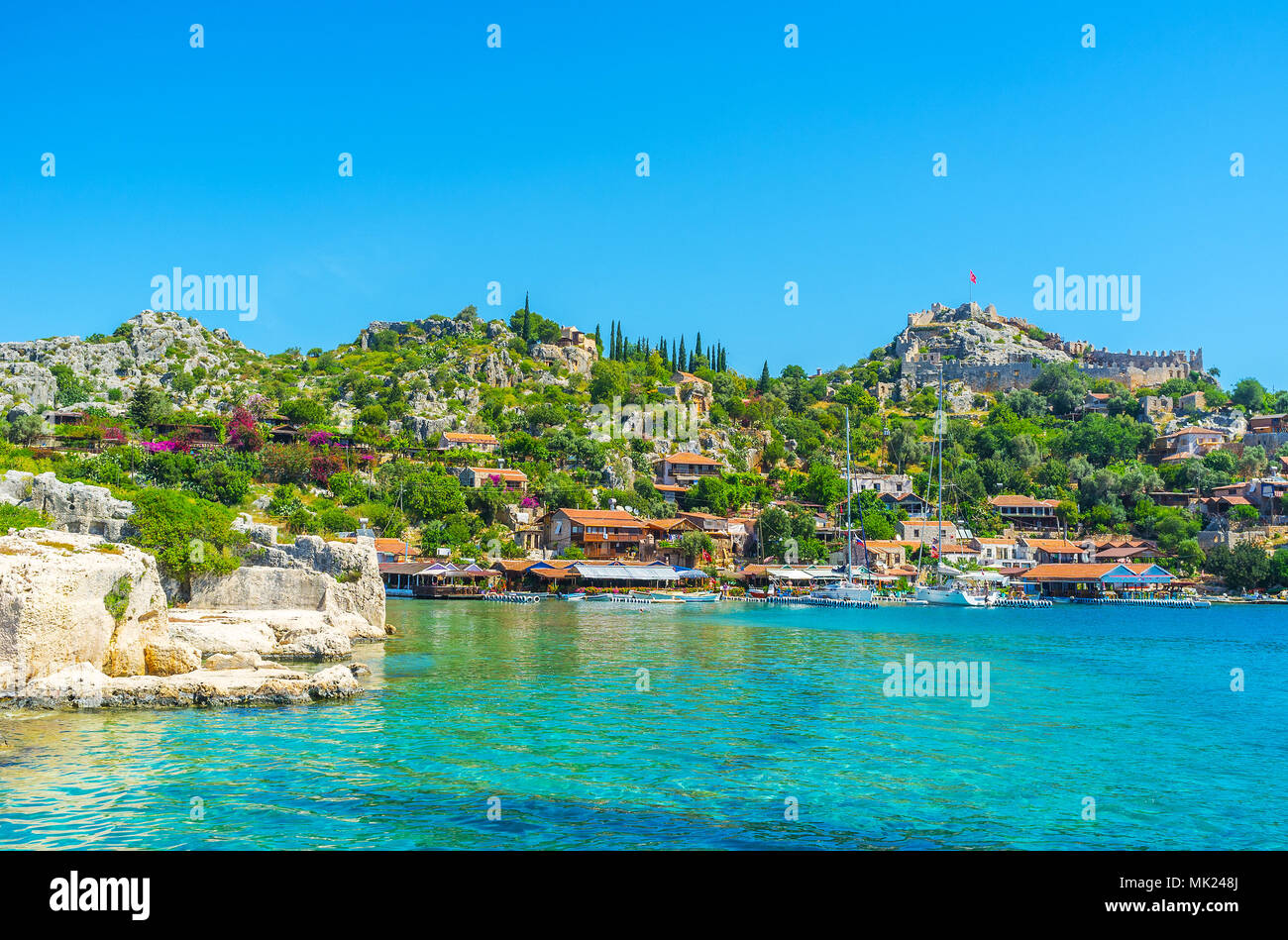 The view on scenic Kalekoy village with lush gardens, small cottages ...