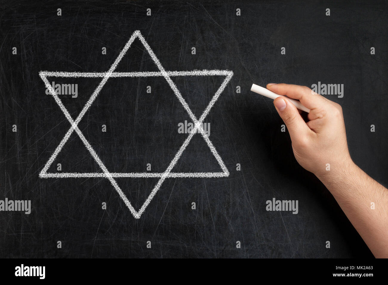 hand with chalk drawing star of david sign on blackboard or chalkboard ...
