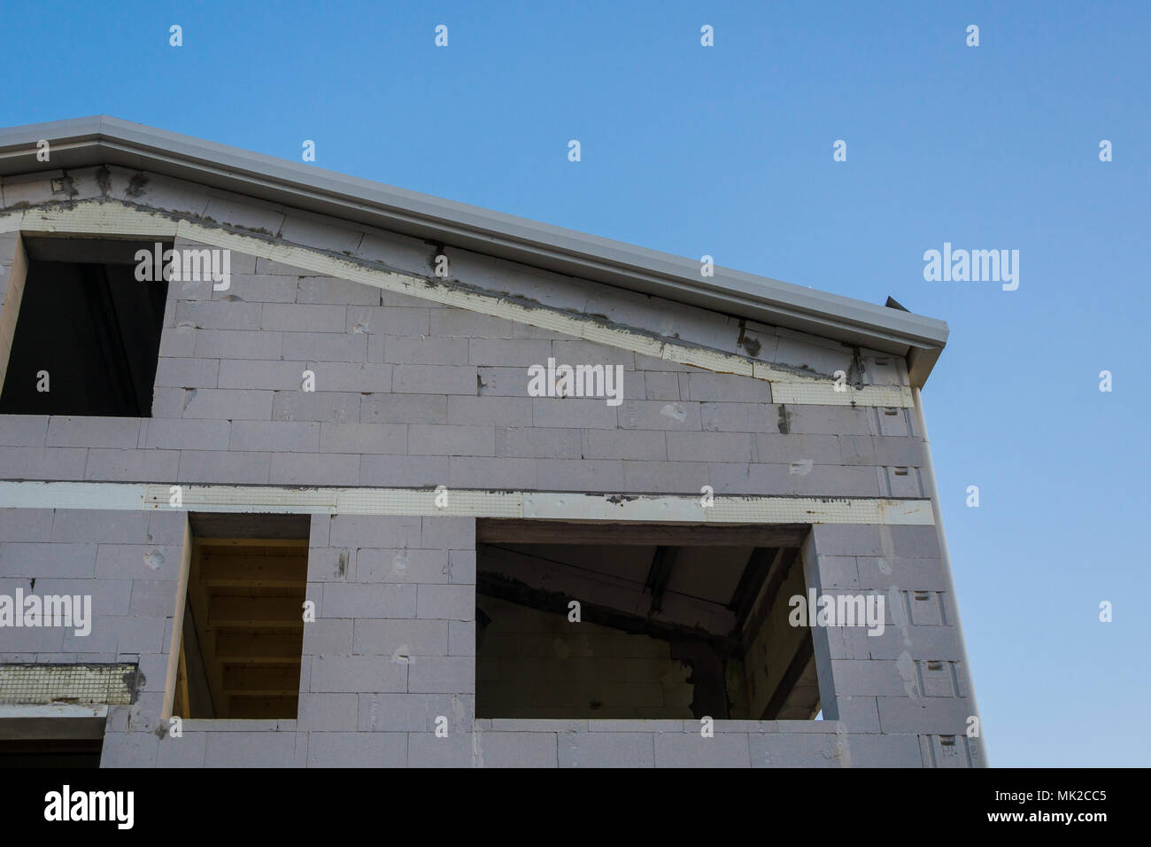 Germany, bare brickwork of new building without windows with blue sky ...