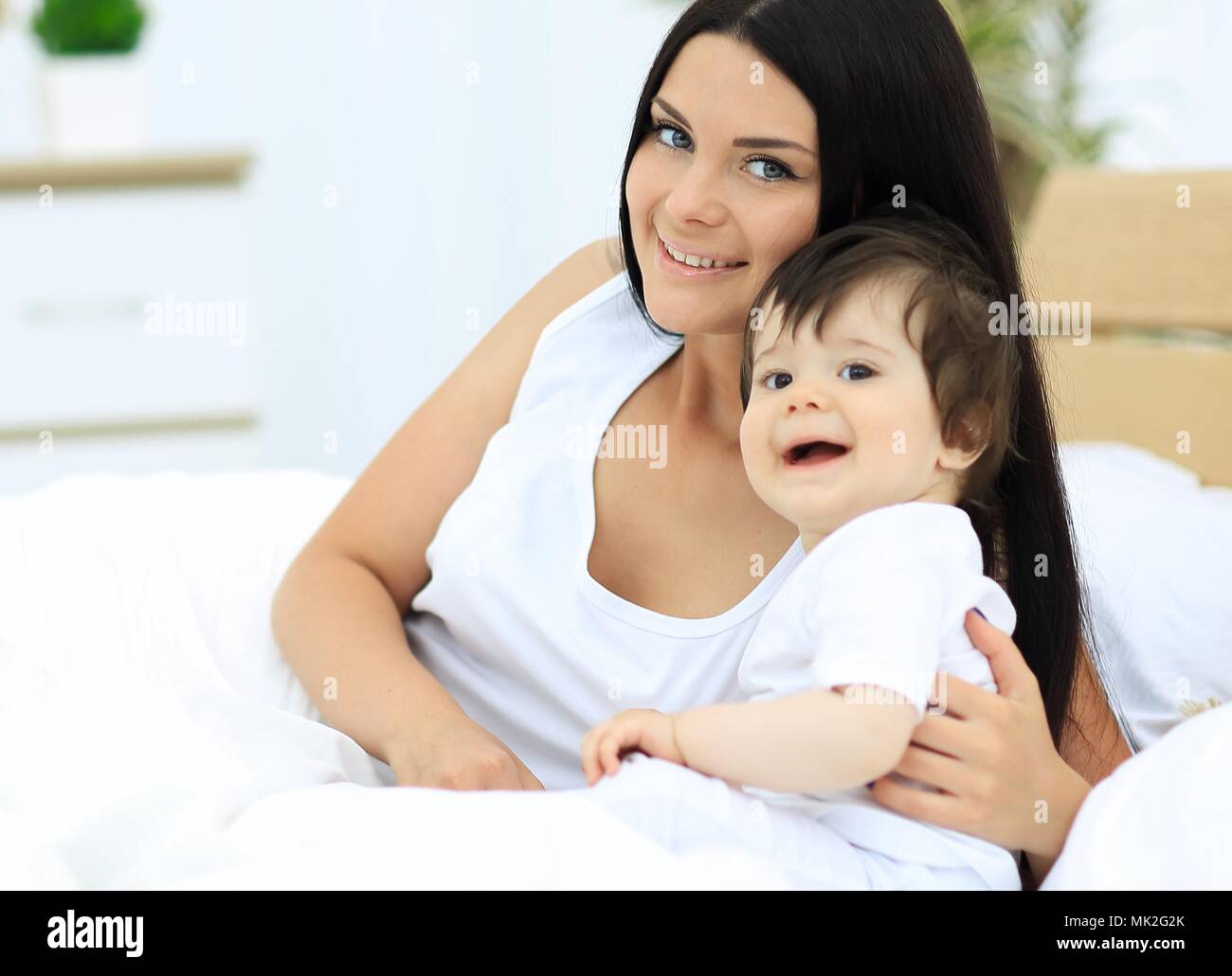 Portrait of a beautiful mother with her baby in the bedroom Stock Photo ...