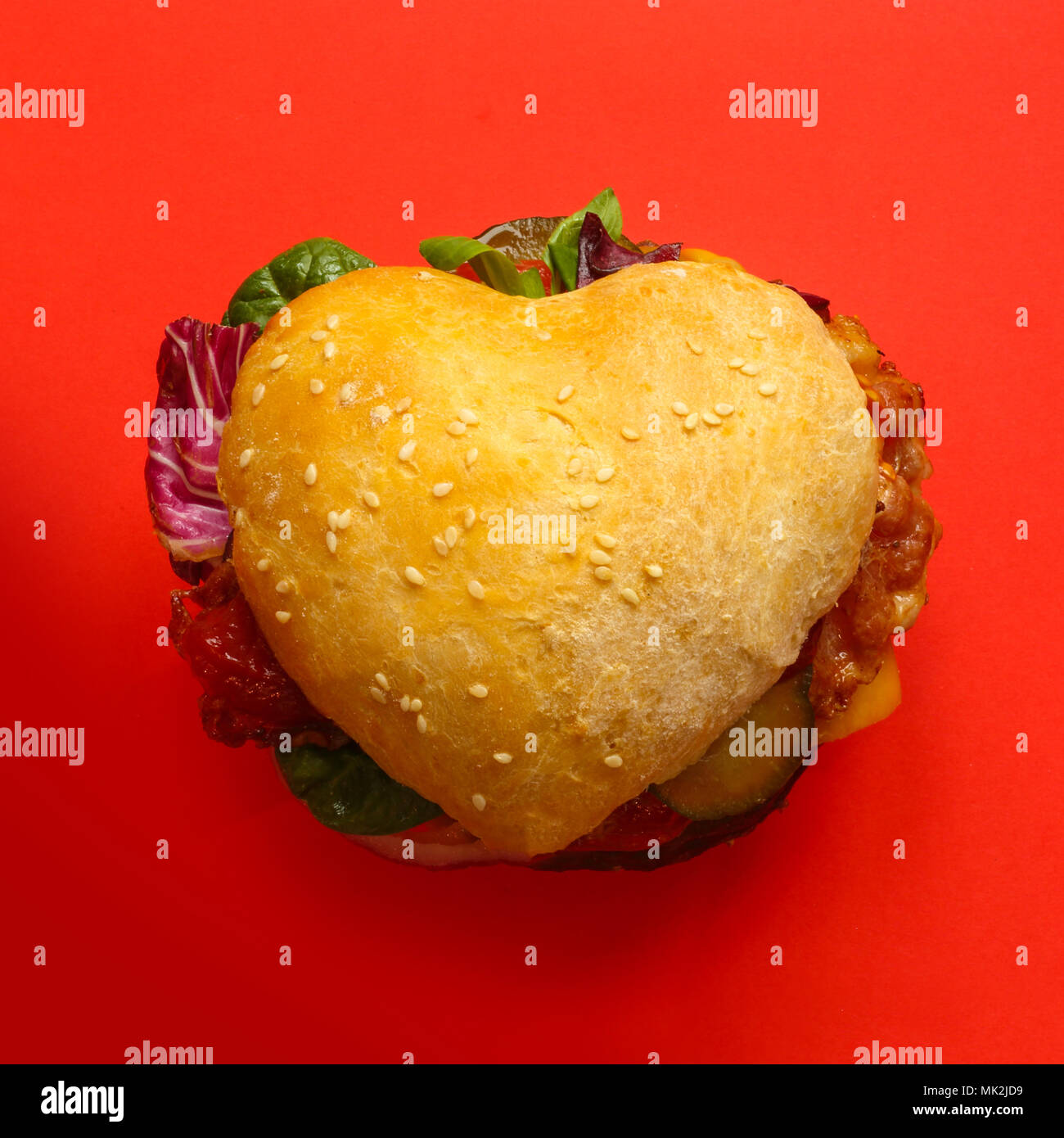 Heart shaped hamburger, love burger fast food concept, on red ...