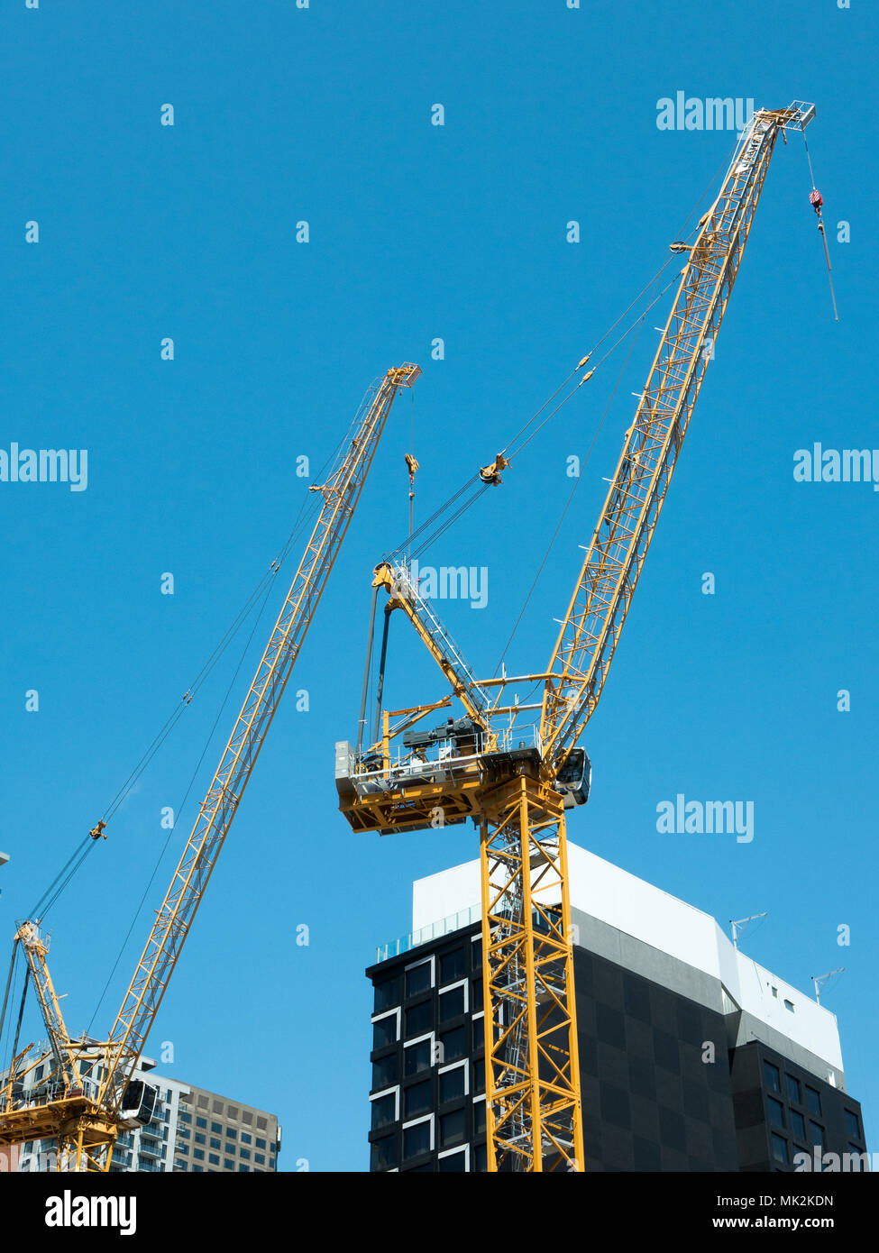 A Yellow Tower Crane on Top of A Steel Skeleton Frame. Blue Sky in The ...