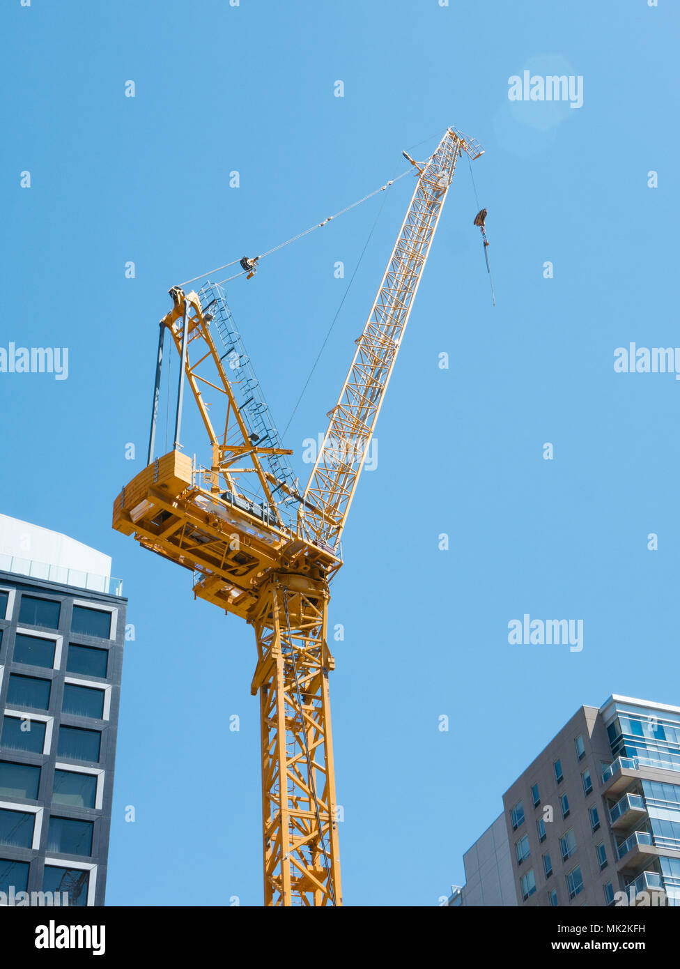 A Yellow Tower Crane on Top of A Steel Skeleton Frame. Blue Sky in The ...