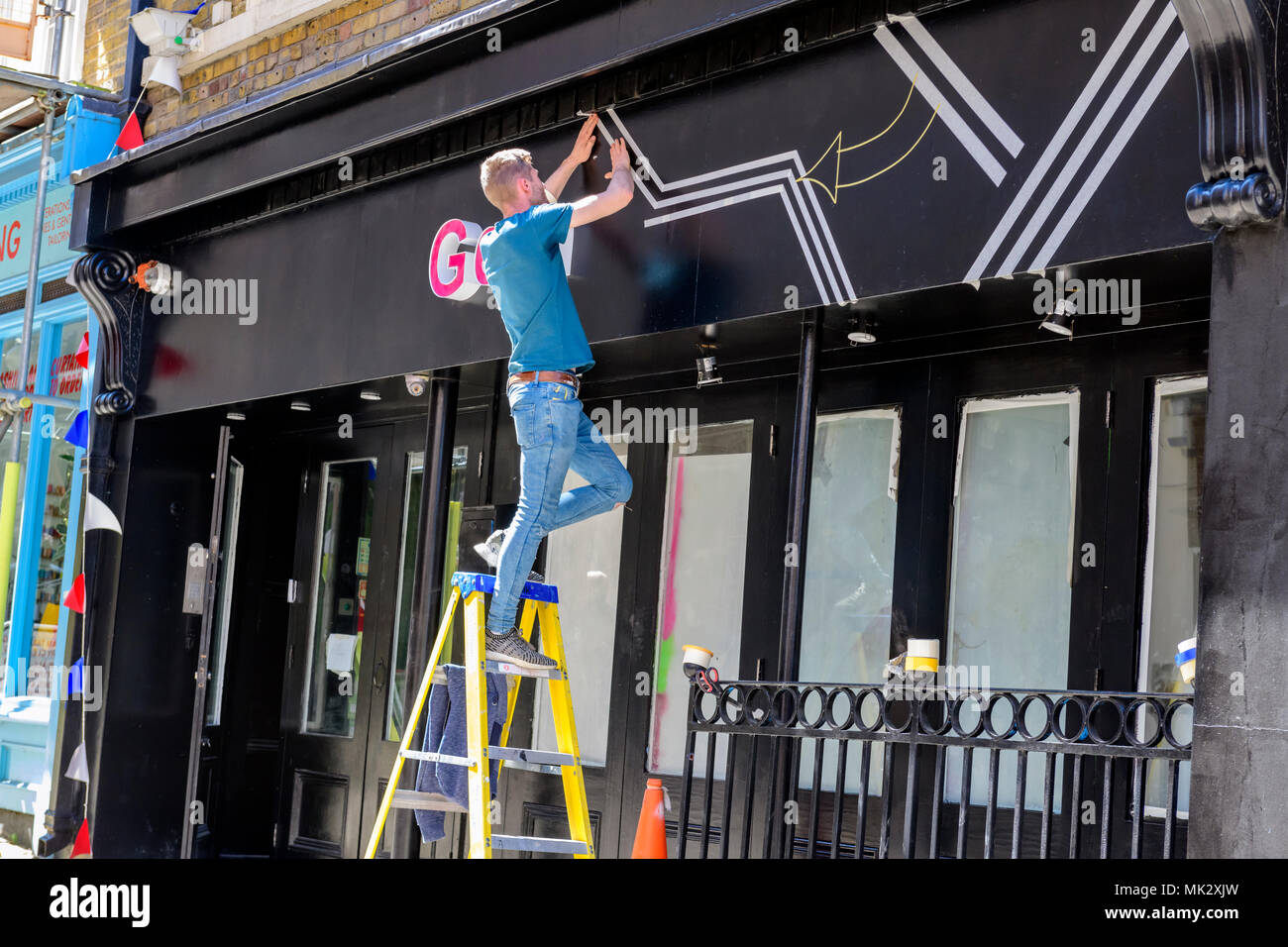 Man preparing to write a shop sign Stock Photo - Alamy