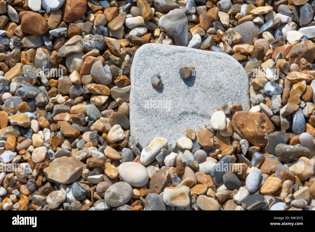Stone with a sad face, on a beach Stock Photo - Alamy