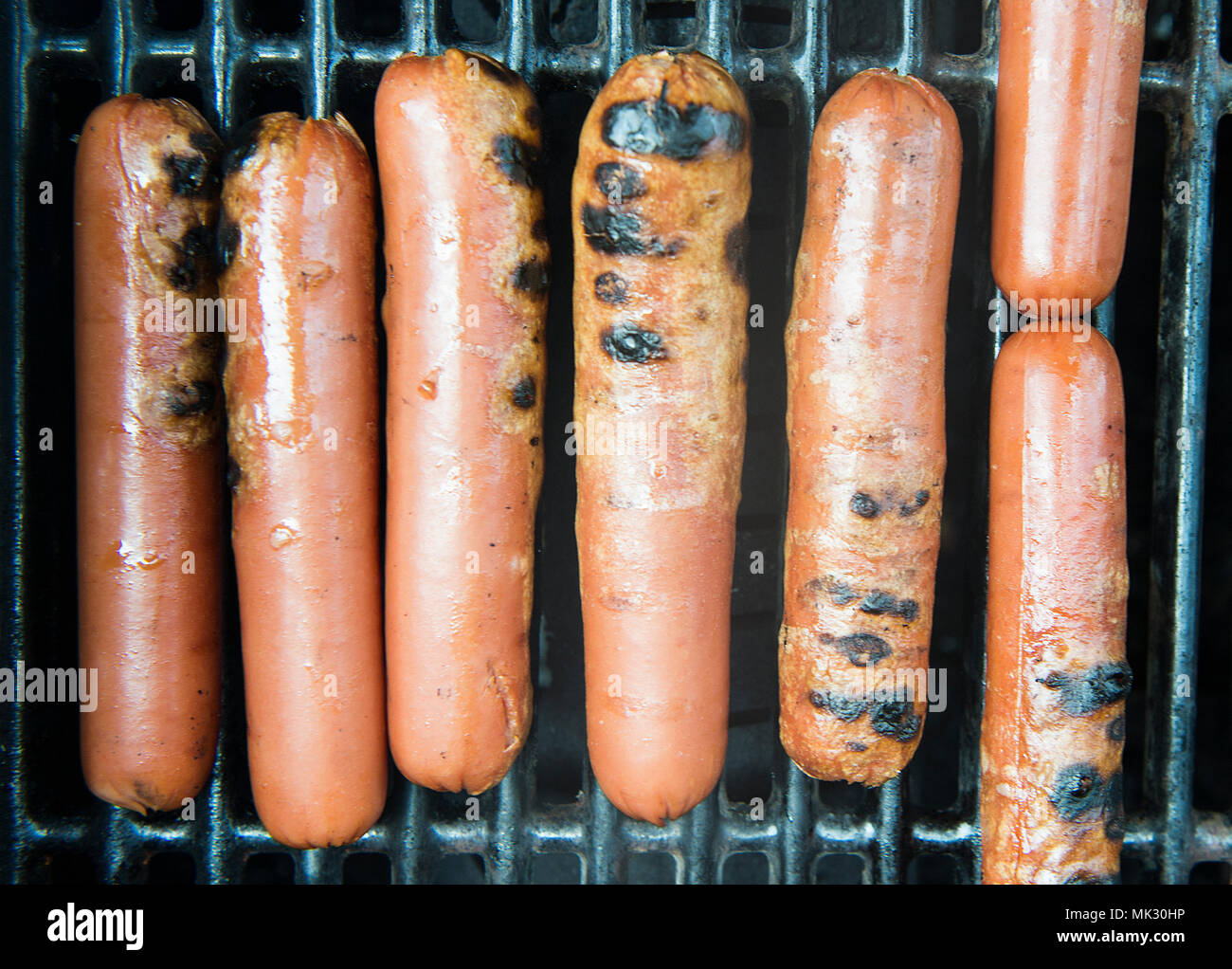 Hot dog sausages cook on a propane barbecue grill Stock Photo - Alamy