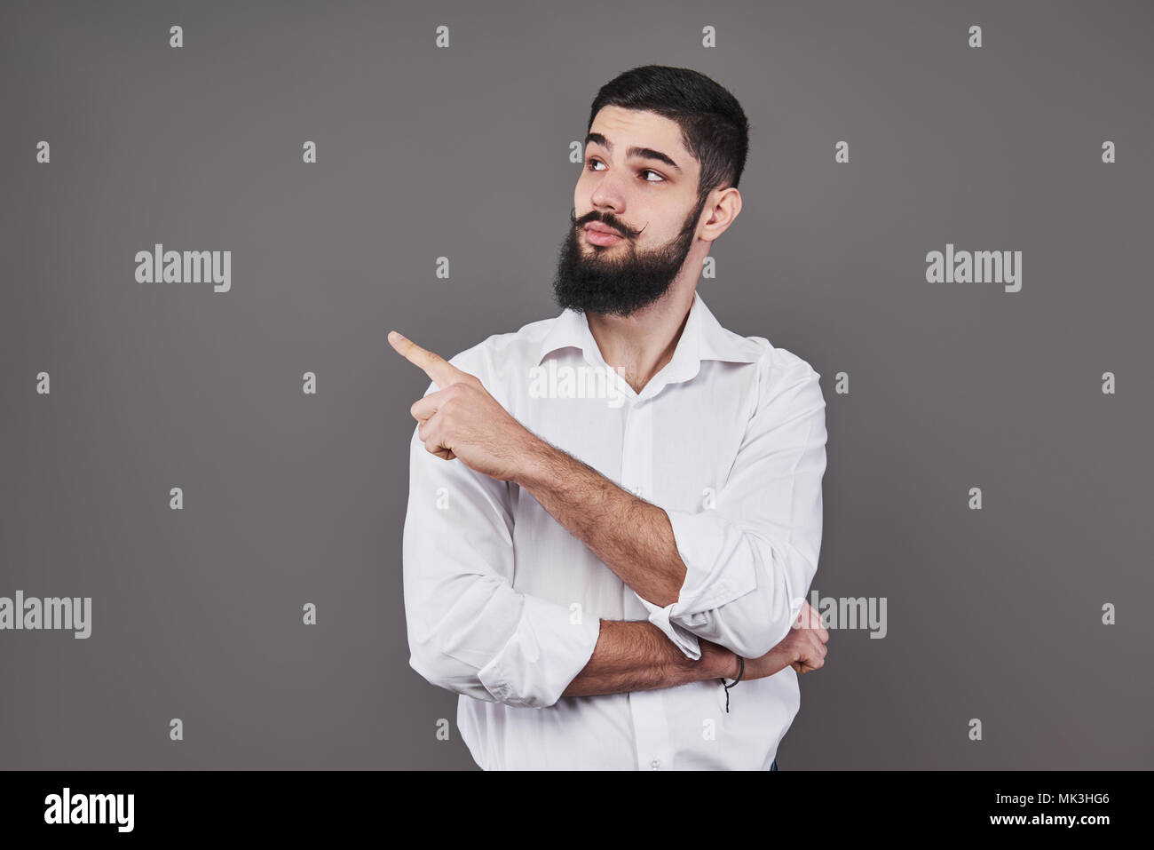 Cheerful handsome man showing direction and pointing with finger Stock ...