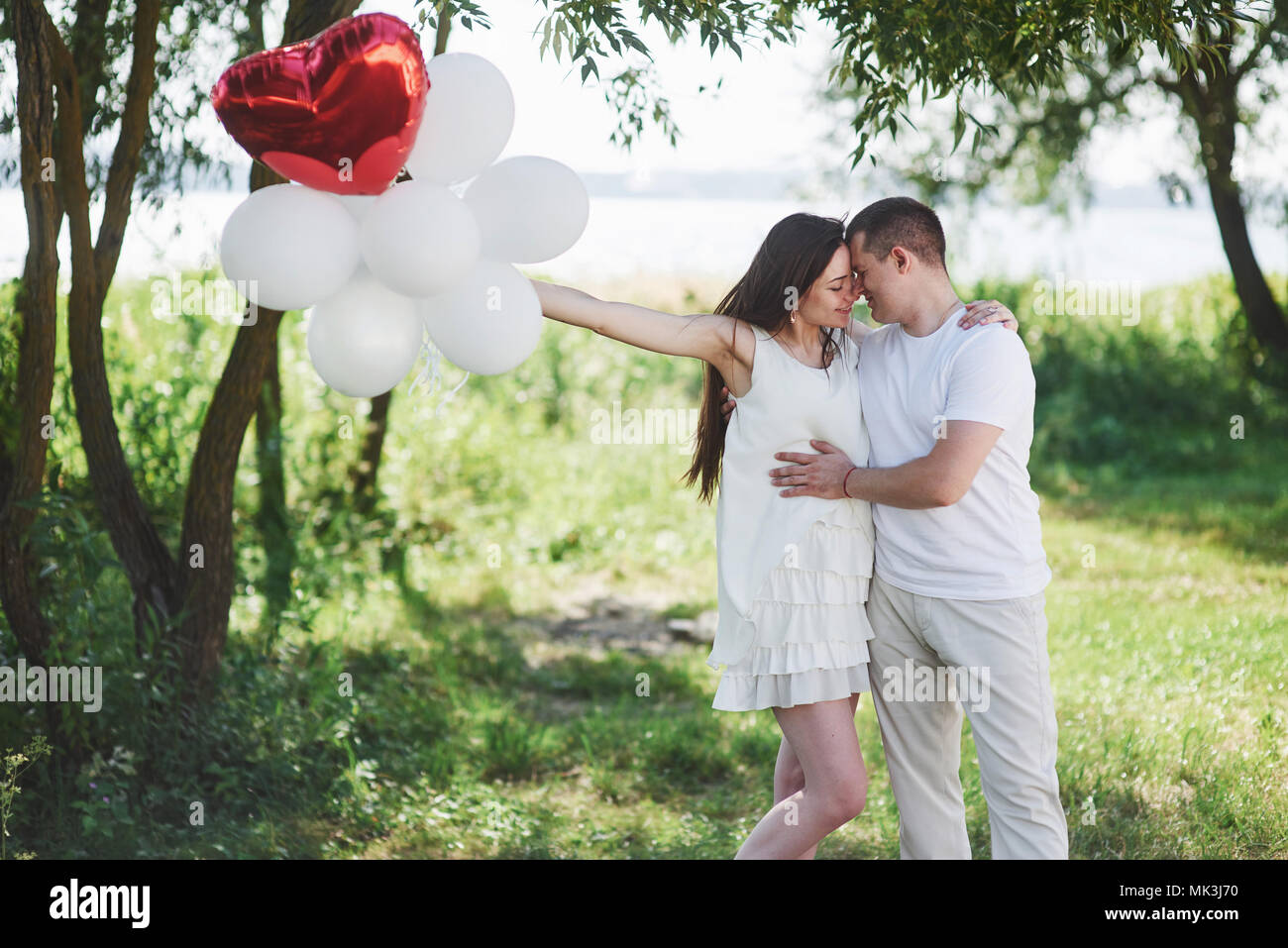 Happy And Young Pregnant Couple Hugging In Nature Romantic Moments