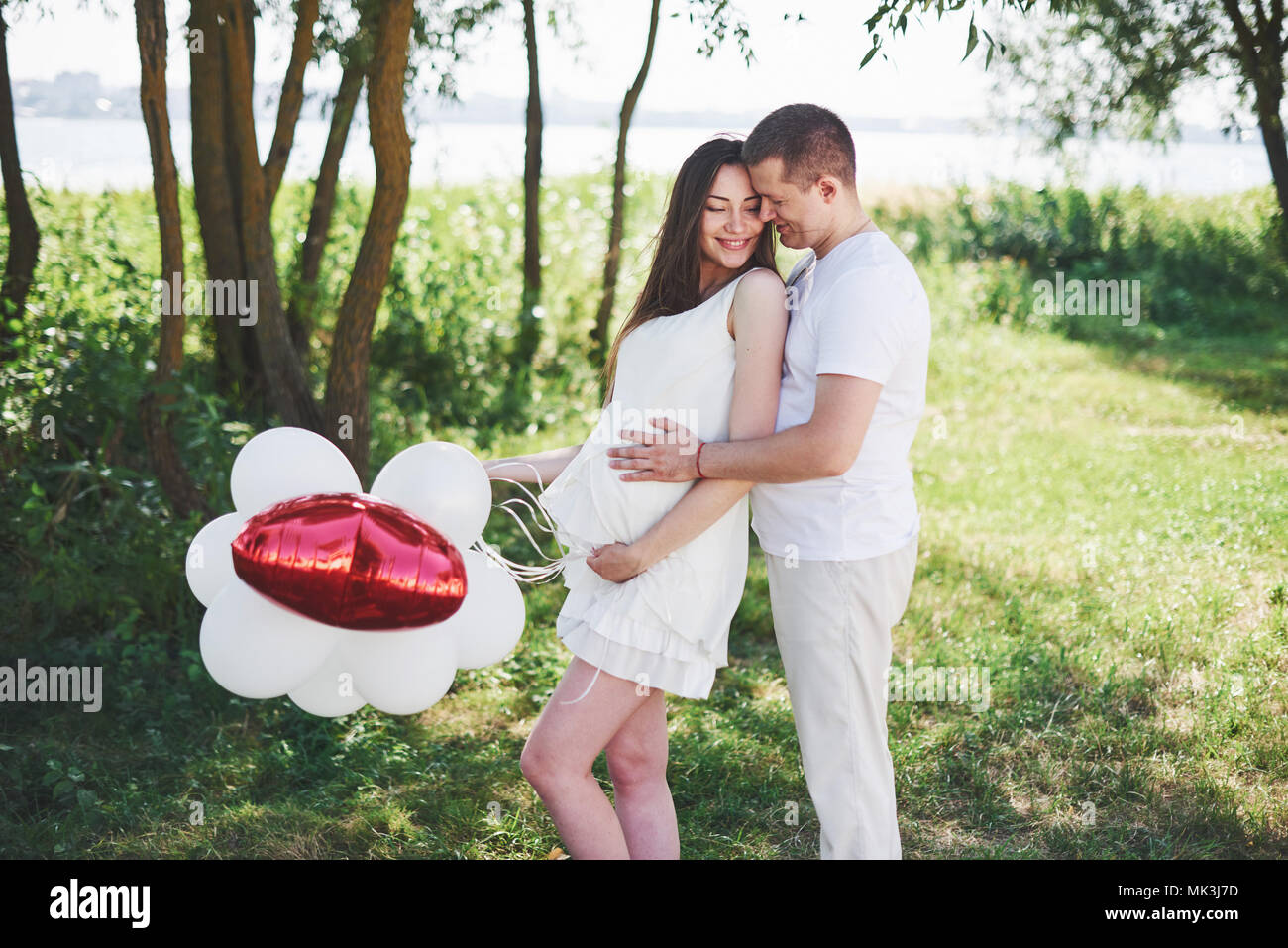 Happy And Young Pregnant Couple Hugging In Nature Romantic Moments