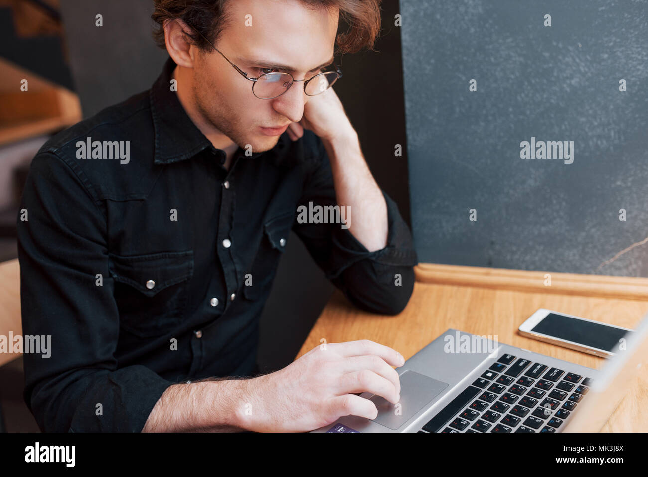 Creative man designer working on his laptop computer while waiting to ...