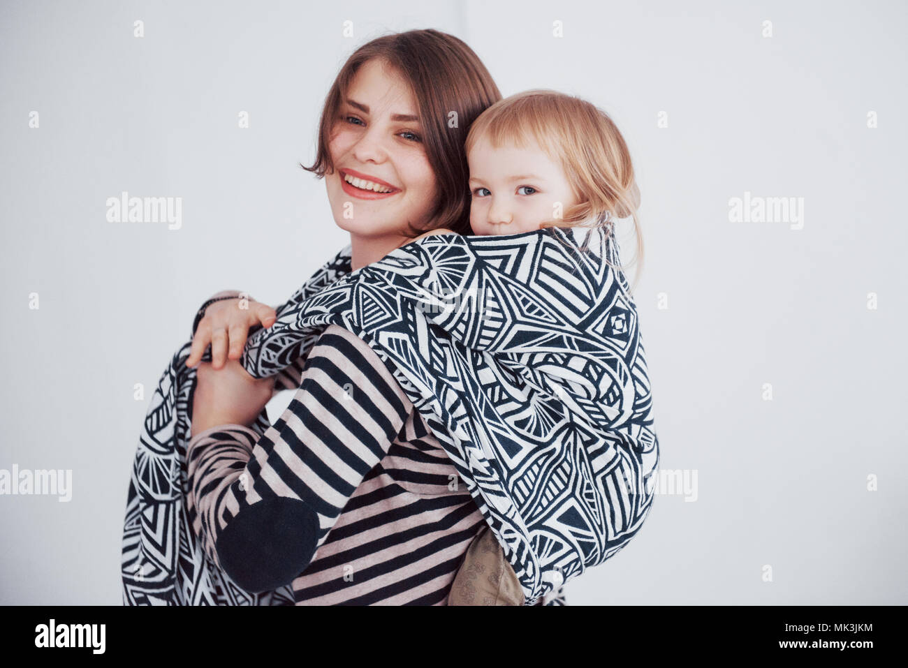 Modern young mother carrying her baby in a sling Stock Photo - Alamy Modern young mother carrying her baby in a sling Stock Photo - Alamy