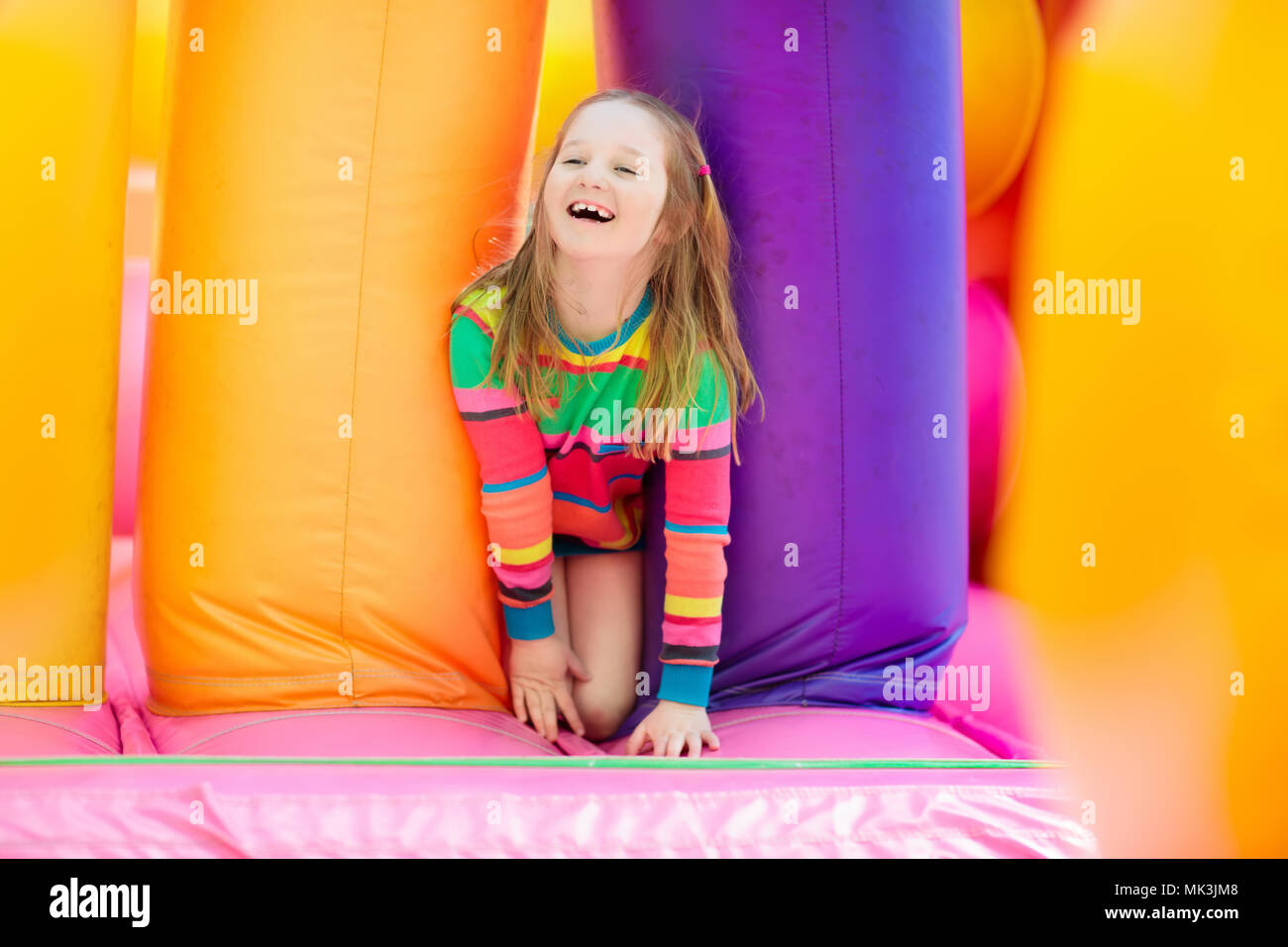 Child jumping on colorful playground trampoline. Kids jump in ...