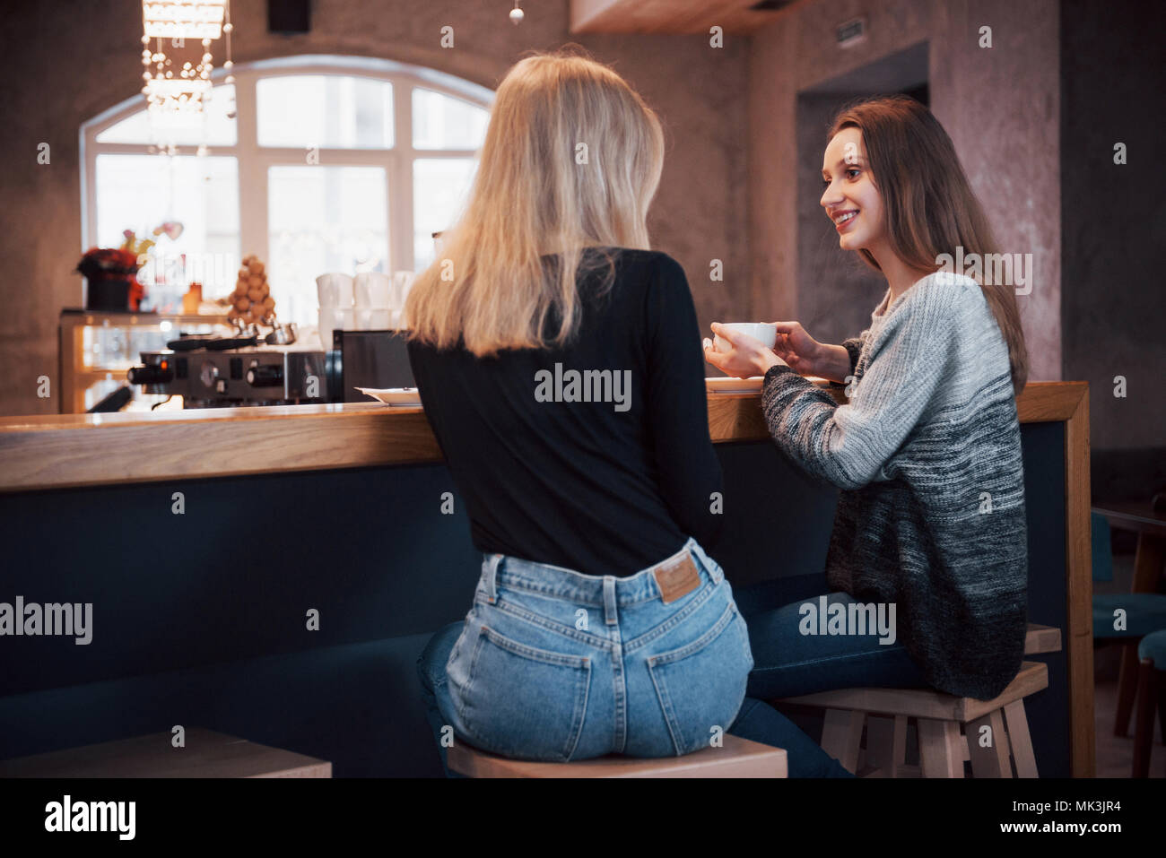 communication and friendship concept - smiling young women with coffee ...