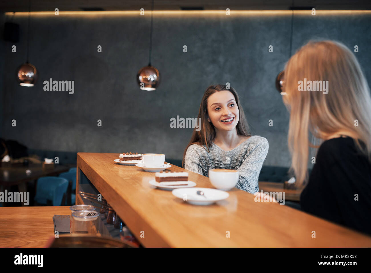 Two girl friends drinking coffee in the cafe Stock Photo - Alamy